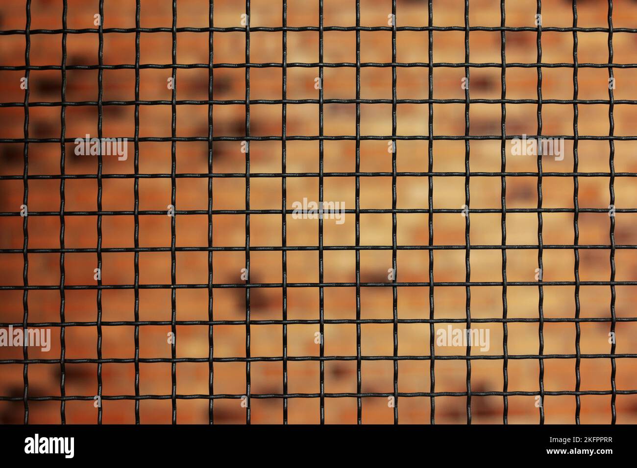 Black metal grating on natural brick background, steel fence indoors ...