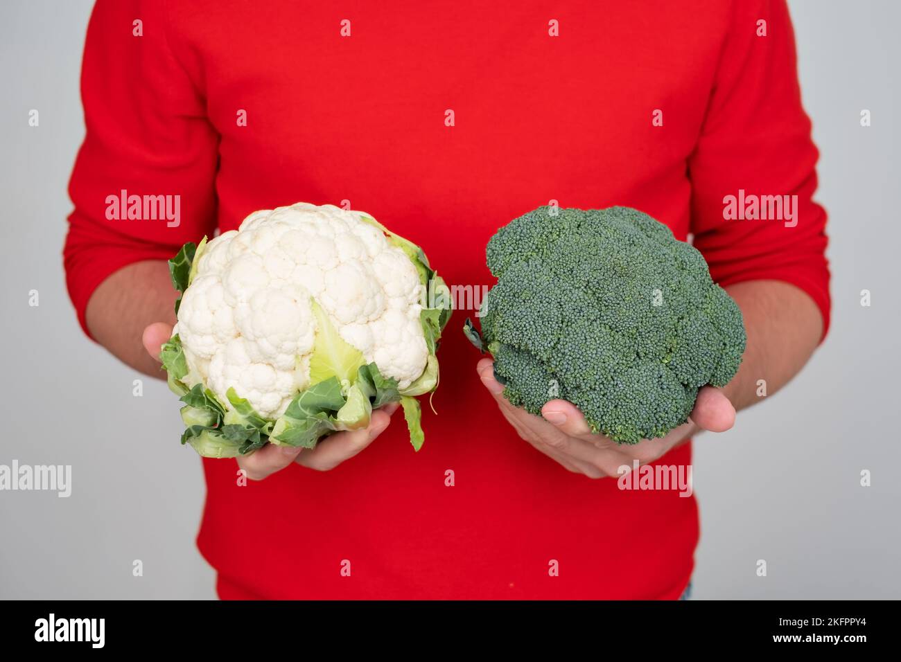 Man holding green fresh broccoli and cauliflower, isolated on white ...