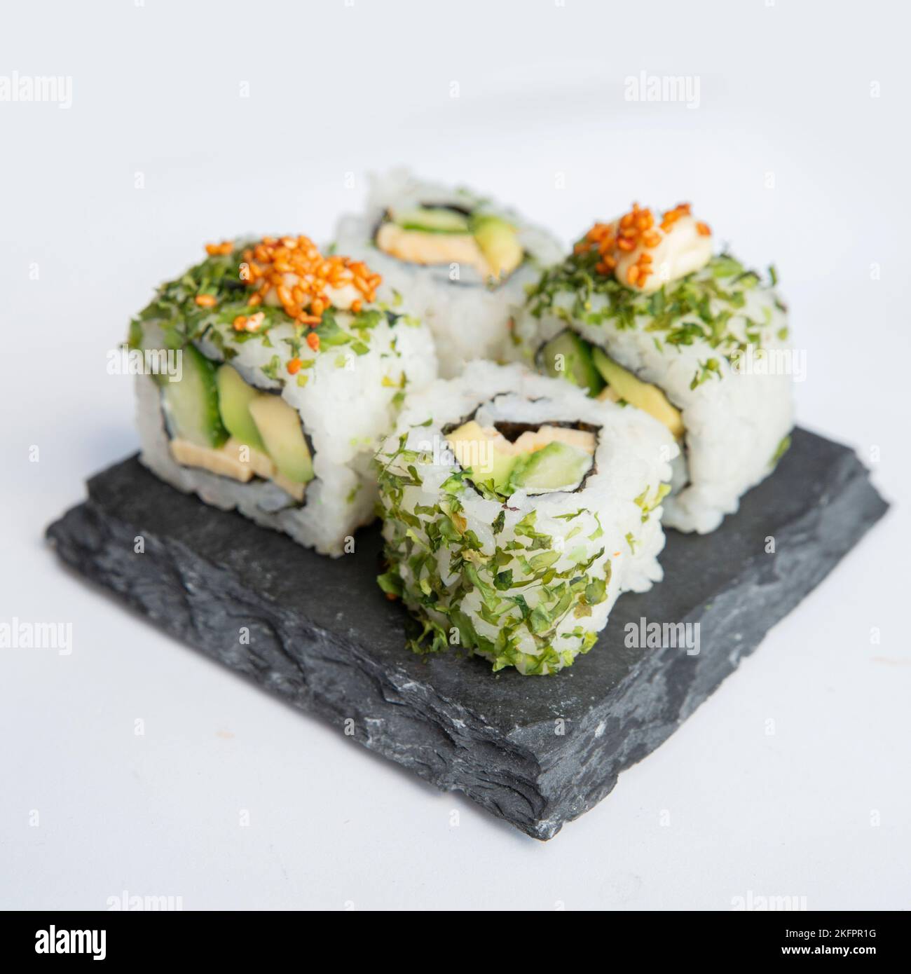 A close-up shot of veggie sushi rolls on a rocky board isolated on a ...