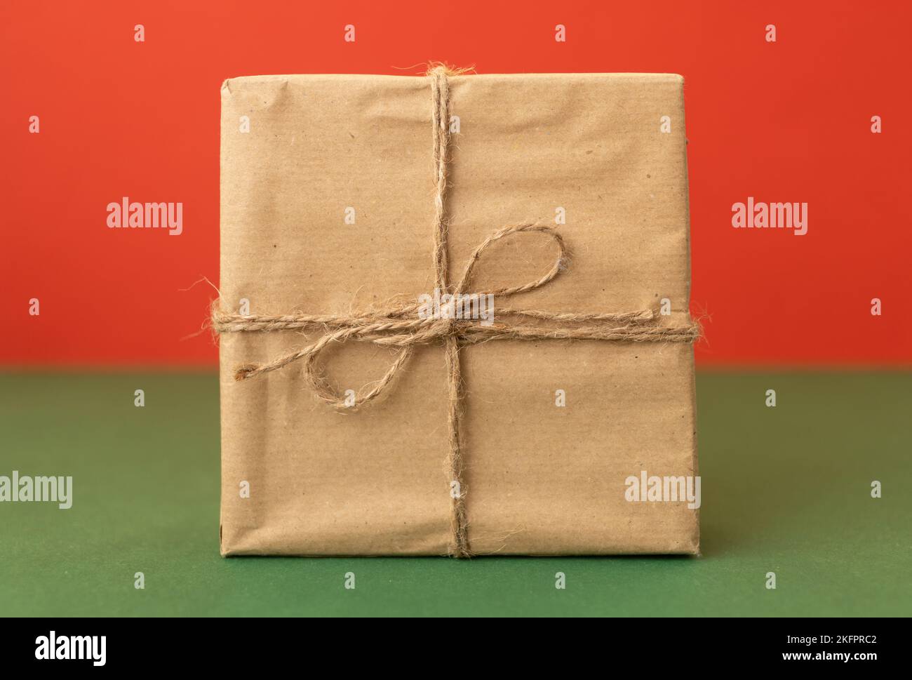 one craft wrapped gift over red background Stock Photo - Alamy