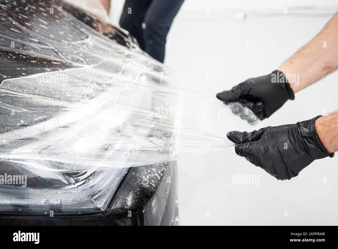 Car wrapping specialist cutting vinyl foil or film on car. Protective ...