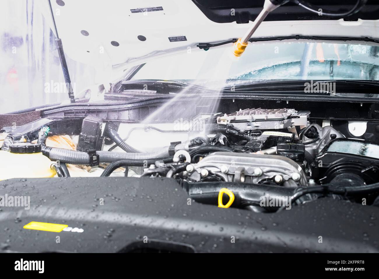 Car detailing maintenance, cleaning engine with the foam and a brush ...