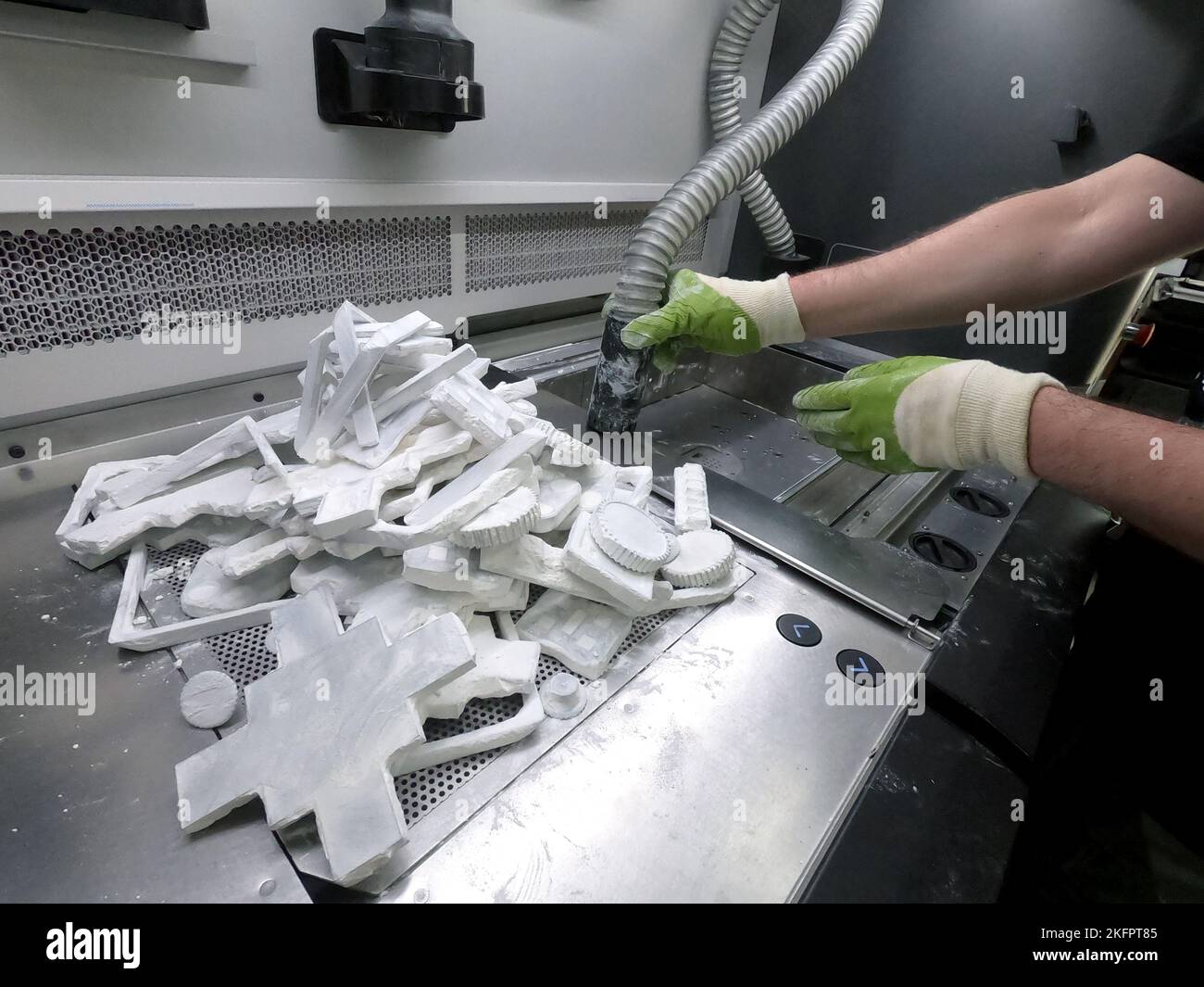Man cleans details printed on industrial 3D printer from white plastic ...
