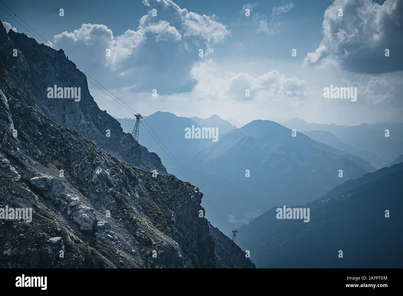 A beautiful view of cable wires over a rocky landscape on a cloudy day ...