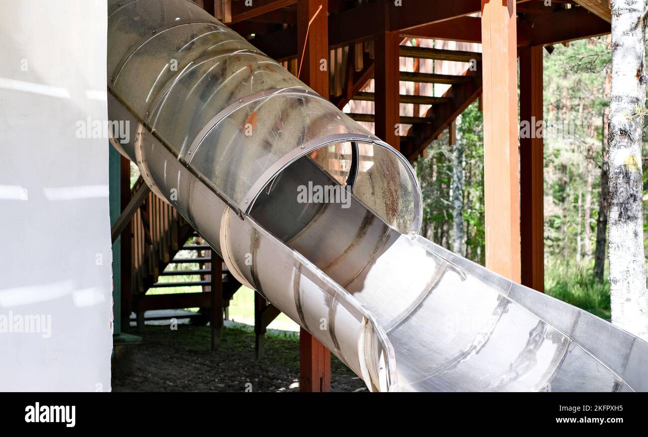 Children's slide in the form of a pipe in an amusement park. Recreation ...