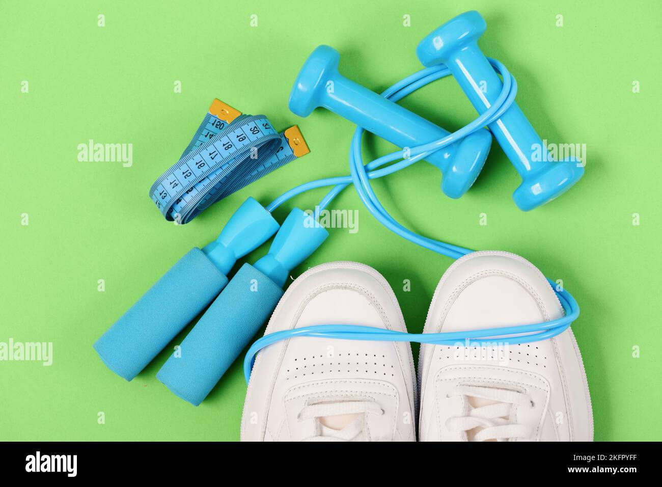 Sneakers with skipping rope and tape on green background Stock Photo ...