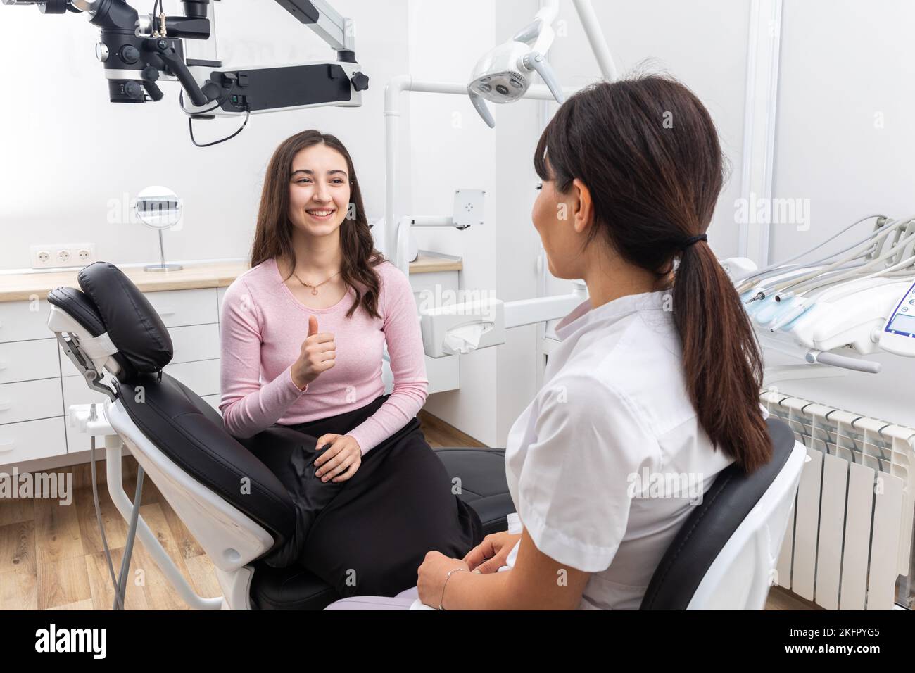 Dentist consulting young patient in dental clinic Stock Photo - Alamy