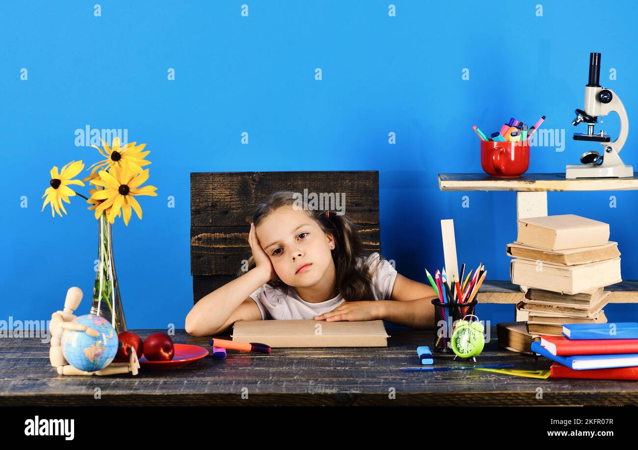 Schoolgirl with colorful stationery, books, globe, clock and flowers ...