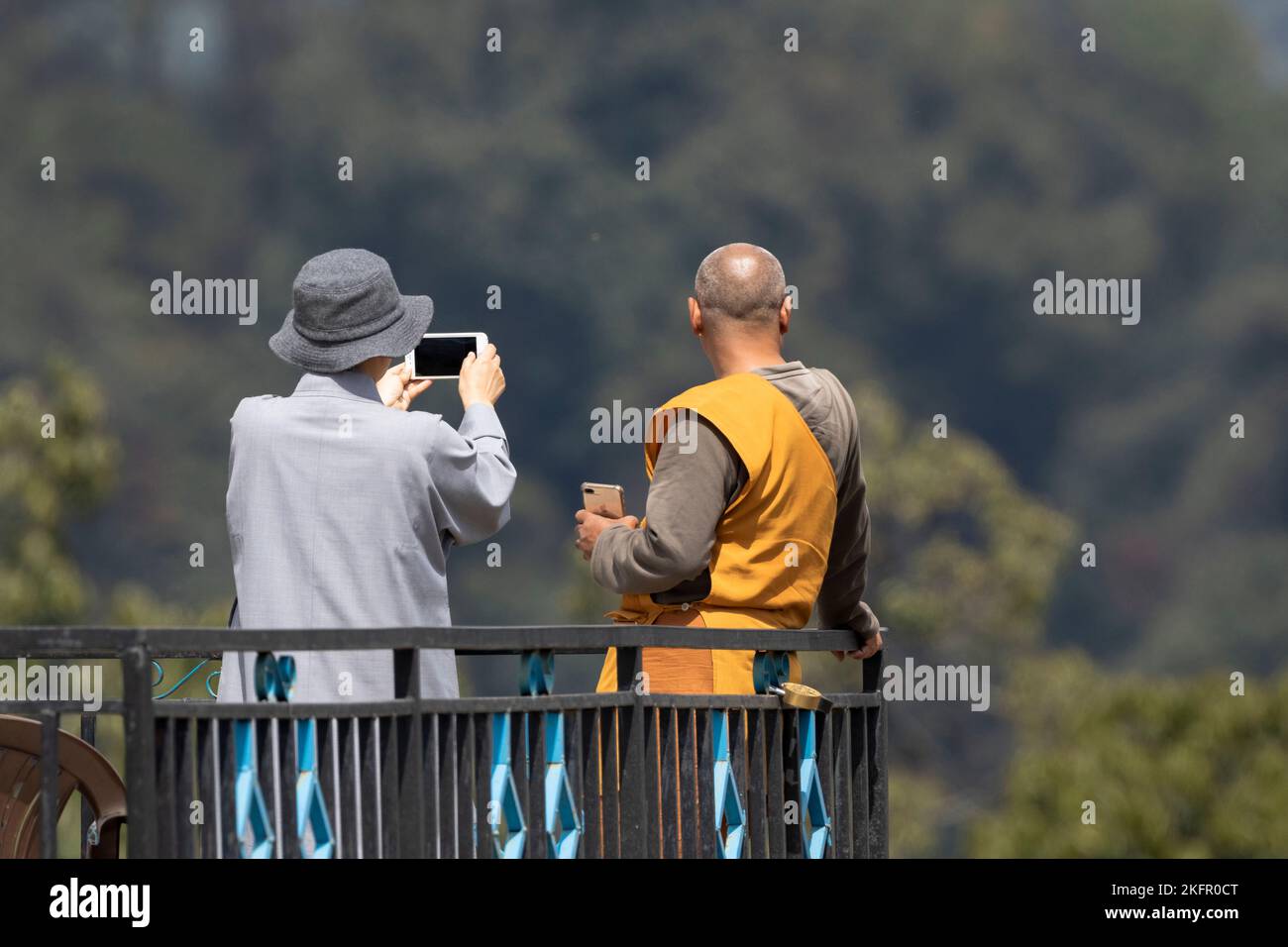 A nun and a monk photograph the landscape with their smartphones ...