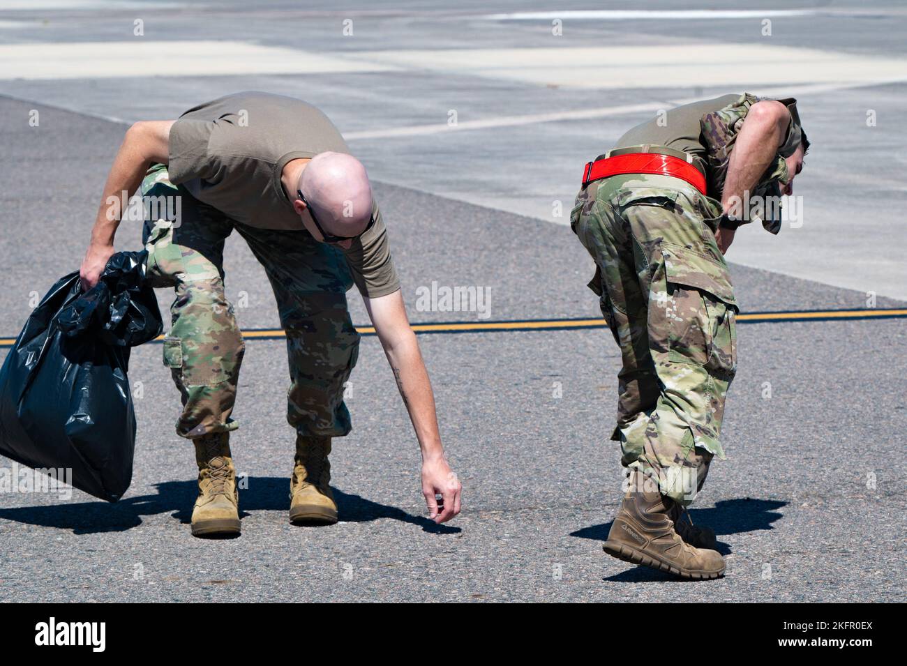 U.S. Airmen assigned to the 6th Maintenance Squadron pick up debris ...