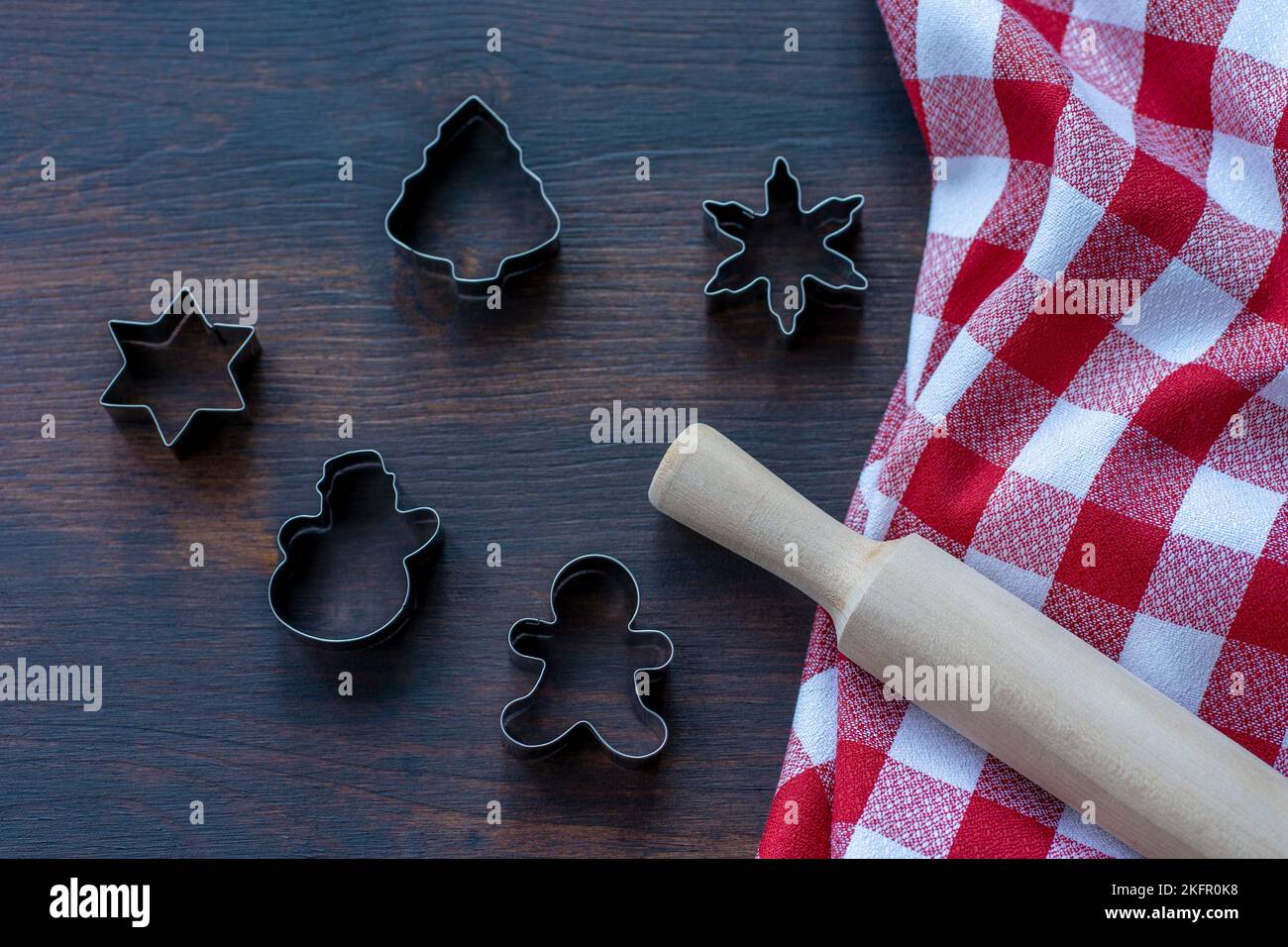 dark wooden table with red chequered tablecloth, rolling pin and ...