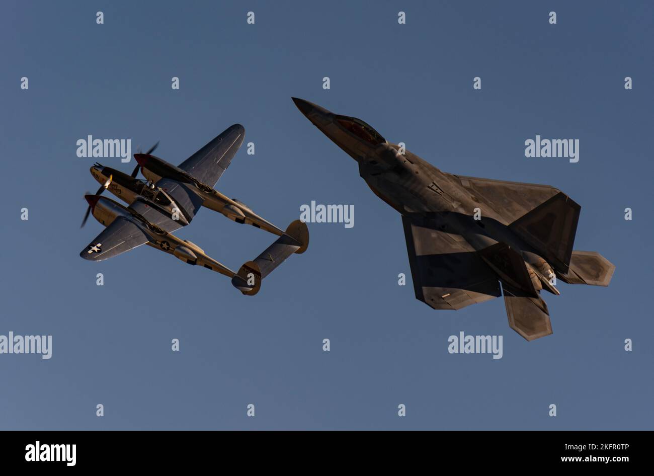 A U.S. Air Force F-22 Raptor and P-38 Lightning fly side-by-side during ...
