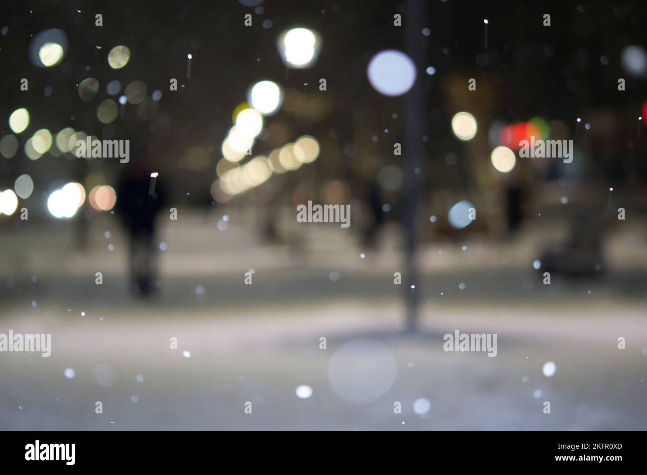 Blurred background. City view, lights, falling snow, night, street ...