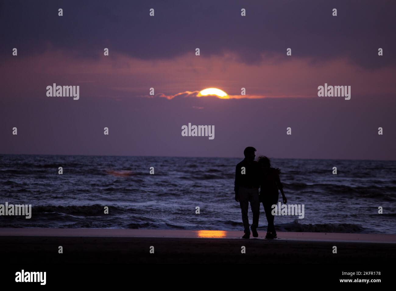 A silhouette of a lovely couple together on Amalfi beach at sunset in ...