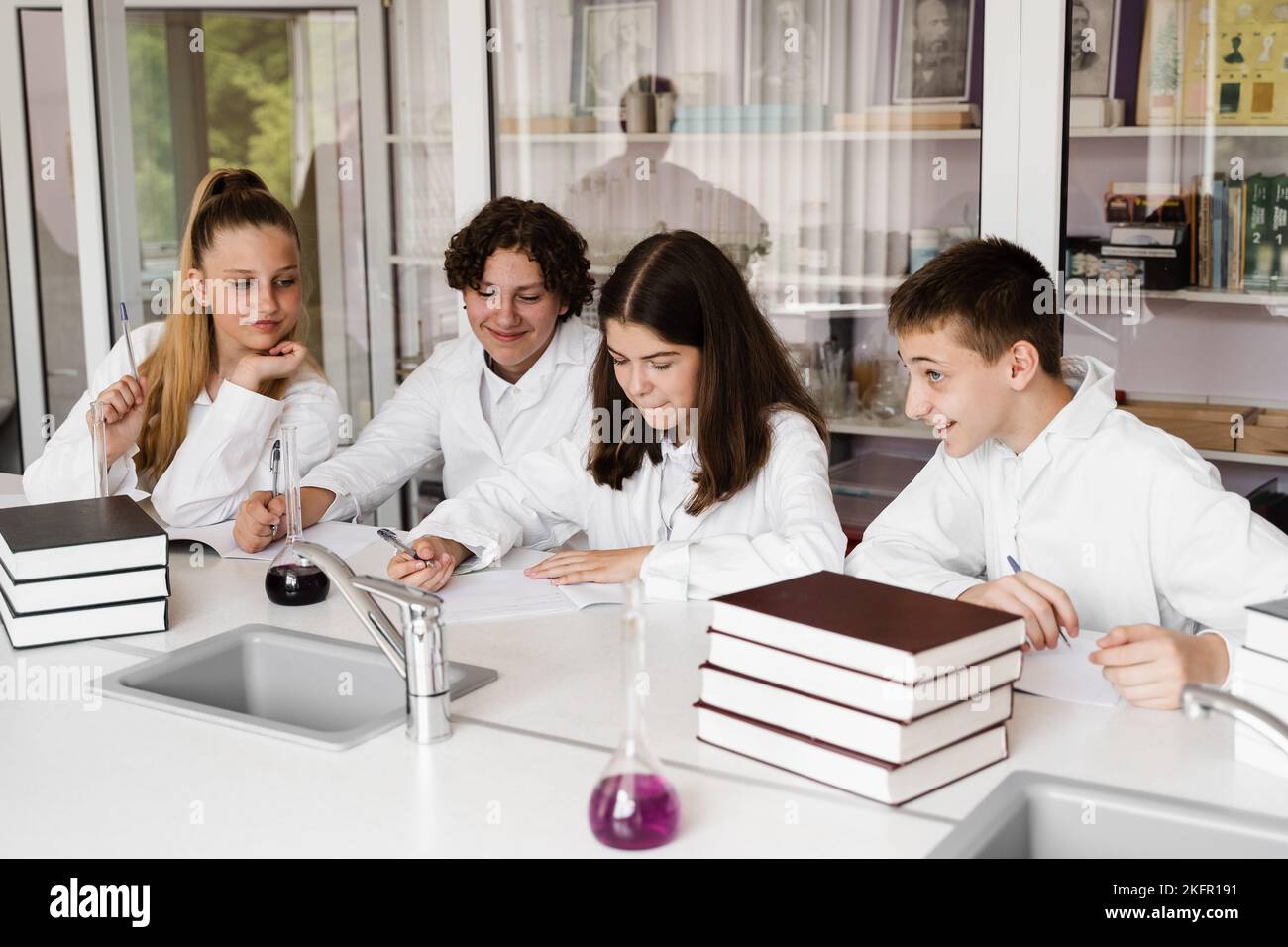 Discussion with a teacher at a chemistry lesson in a laboratory. Group ...