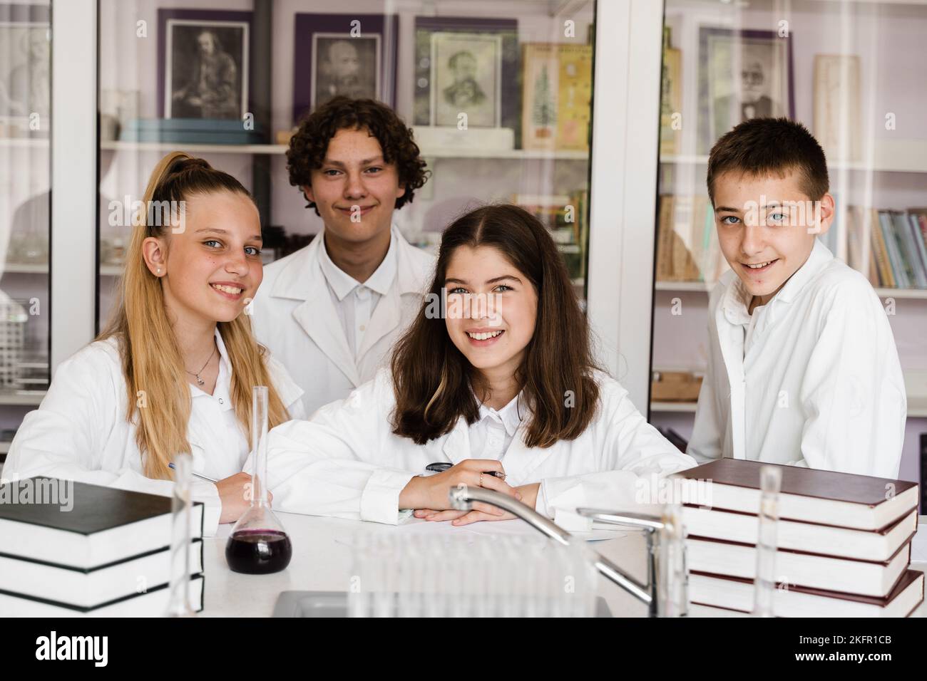 School education. Cheerful classmates in chemistry lesson hold flasks ...