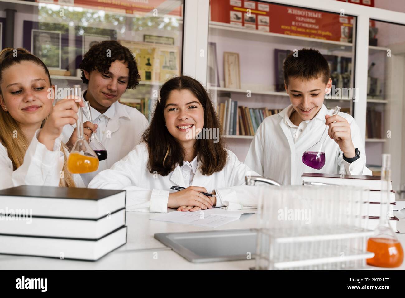 Schoolchildren studying at chemistry lesson in classrom. Pupils writing ...