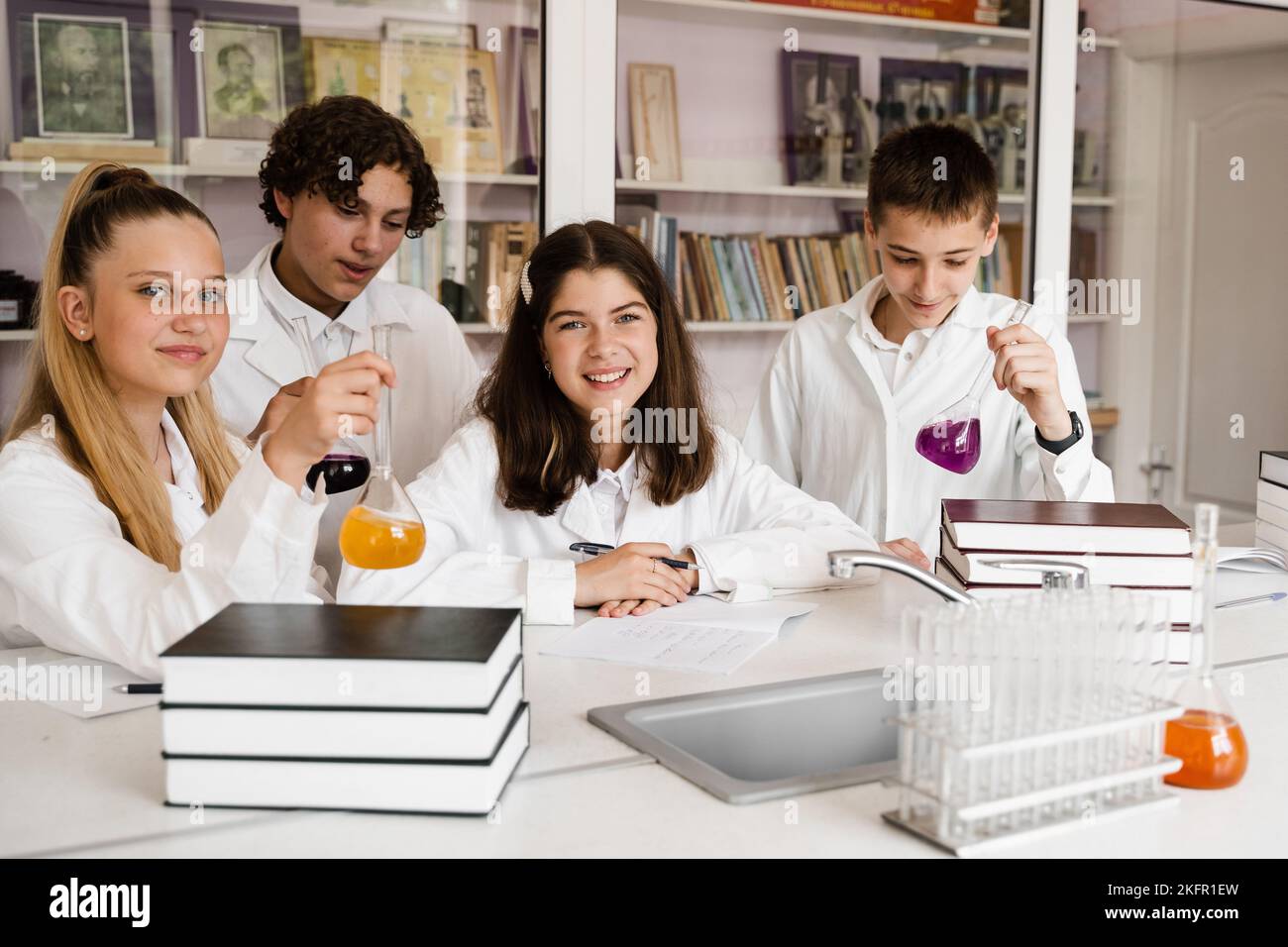 Schoolchildren studying at chemistry lesson in classrom. Pupils writing ...