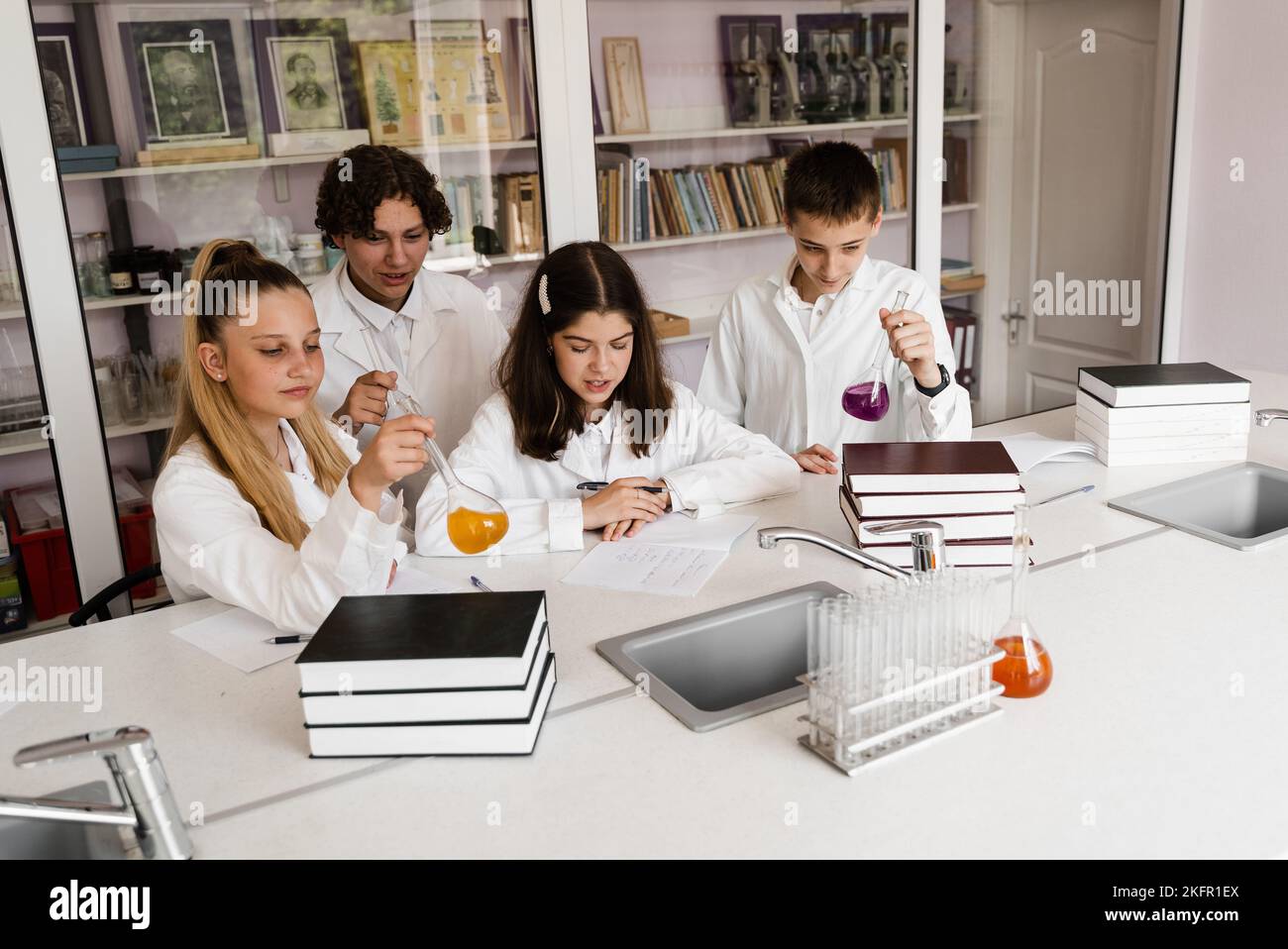 Schoolchildren studying at chemistry lesson in classrom. Pupils writing ...