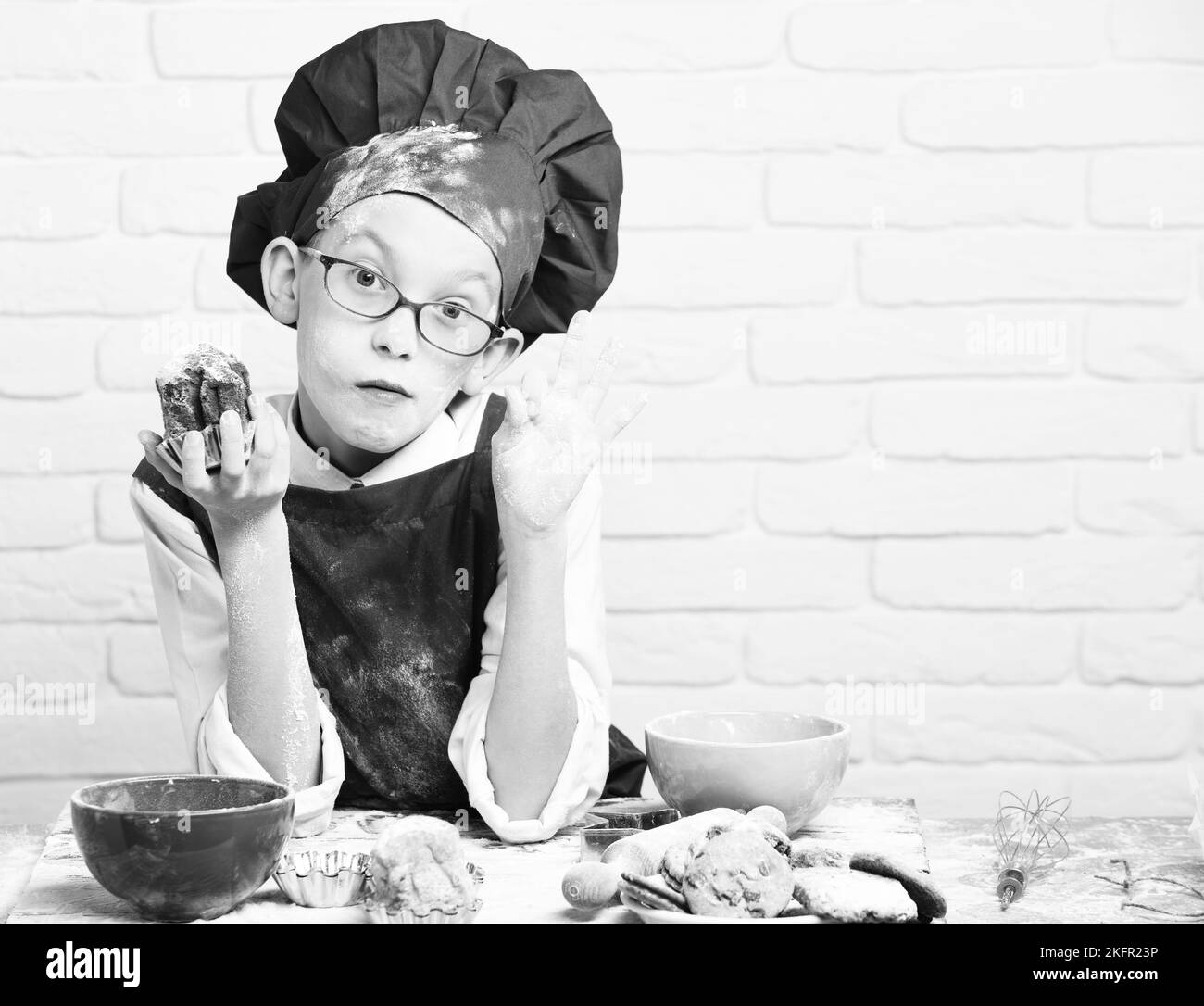 young boy cute cook chef in red uniform and hat on stained face with ...