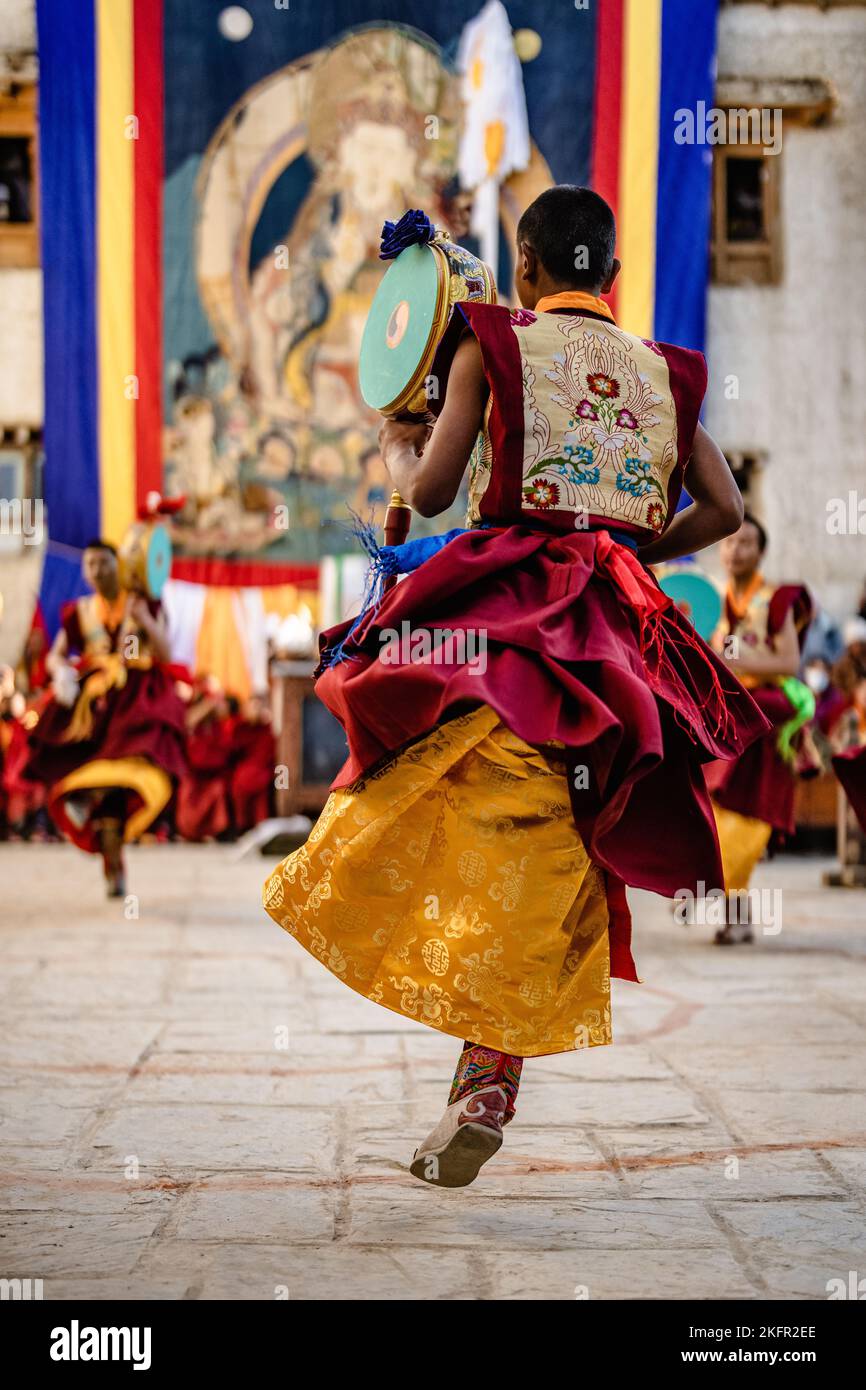 A Tibetan Buddhist in traditional outfit performing Dance with a Damaru ...
