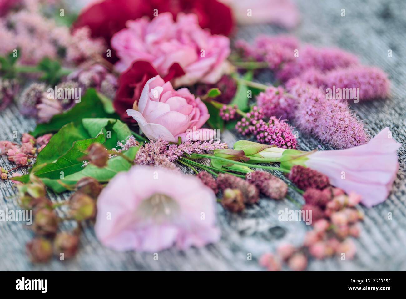 A closeup of a pastel-colored bouquet with roses and morning glories on ...