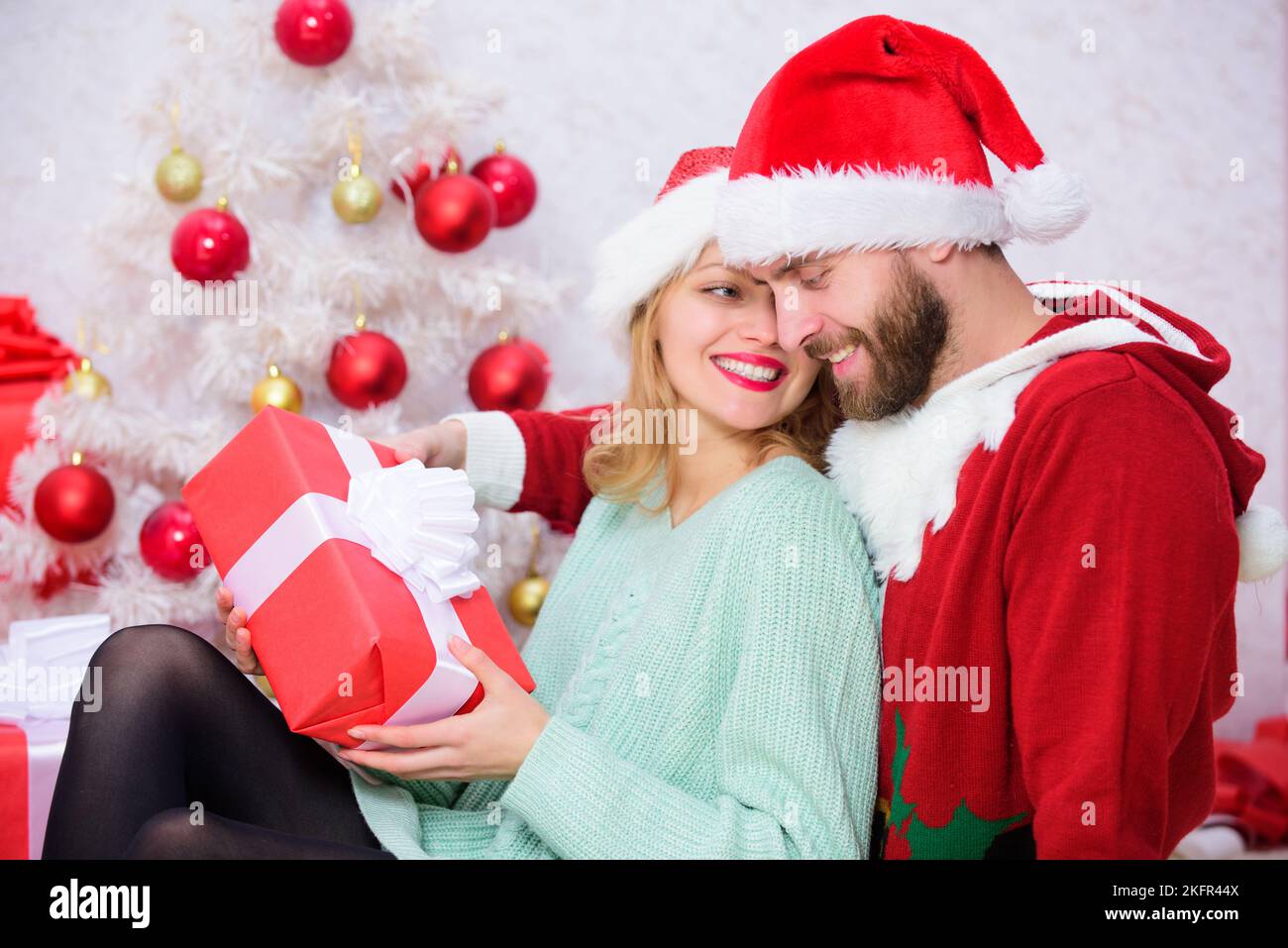 Celebrating christmas together. Loving couple cuddle smiling while ...