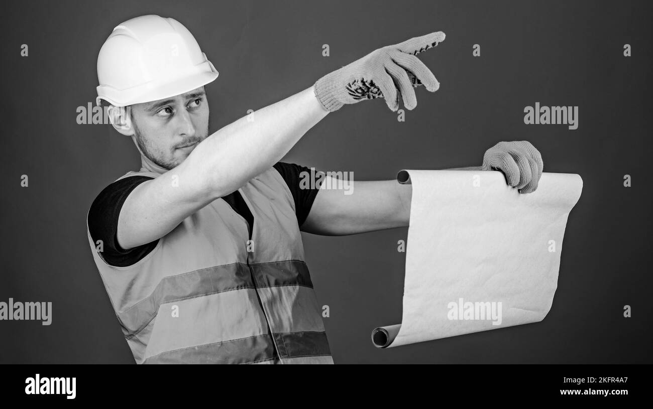 Man in helmet, hard hat holds building plan, controls works, red ...