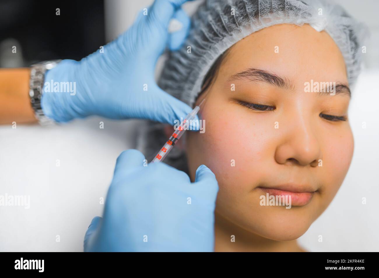 Anti-aging procedure. Closeup portrait of beautiful clear-skinned Asian ...