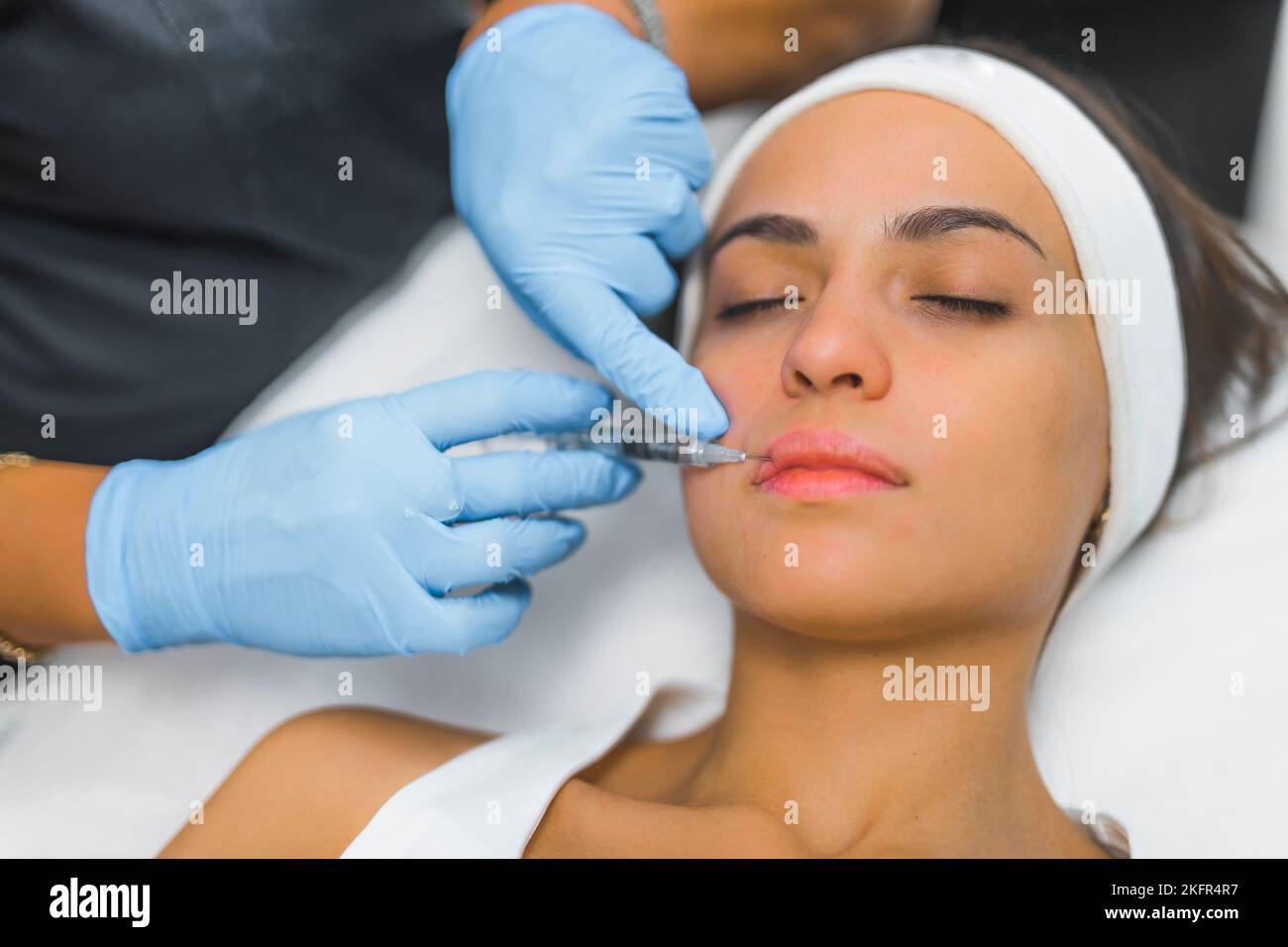 Aesthetic medicine concept. Lip filler procedure closeup. Attractive ...