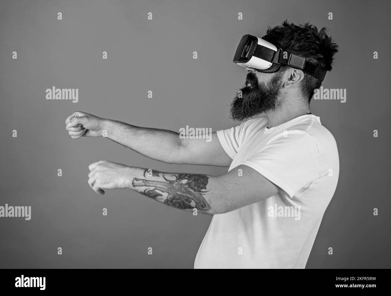 Hipster on confident face driving bike in virtual reality with modern digital gadget. Man with ...