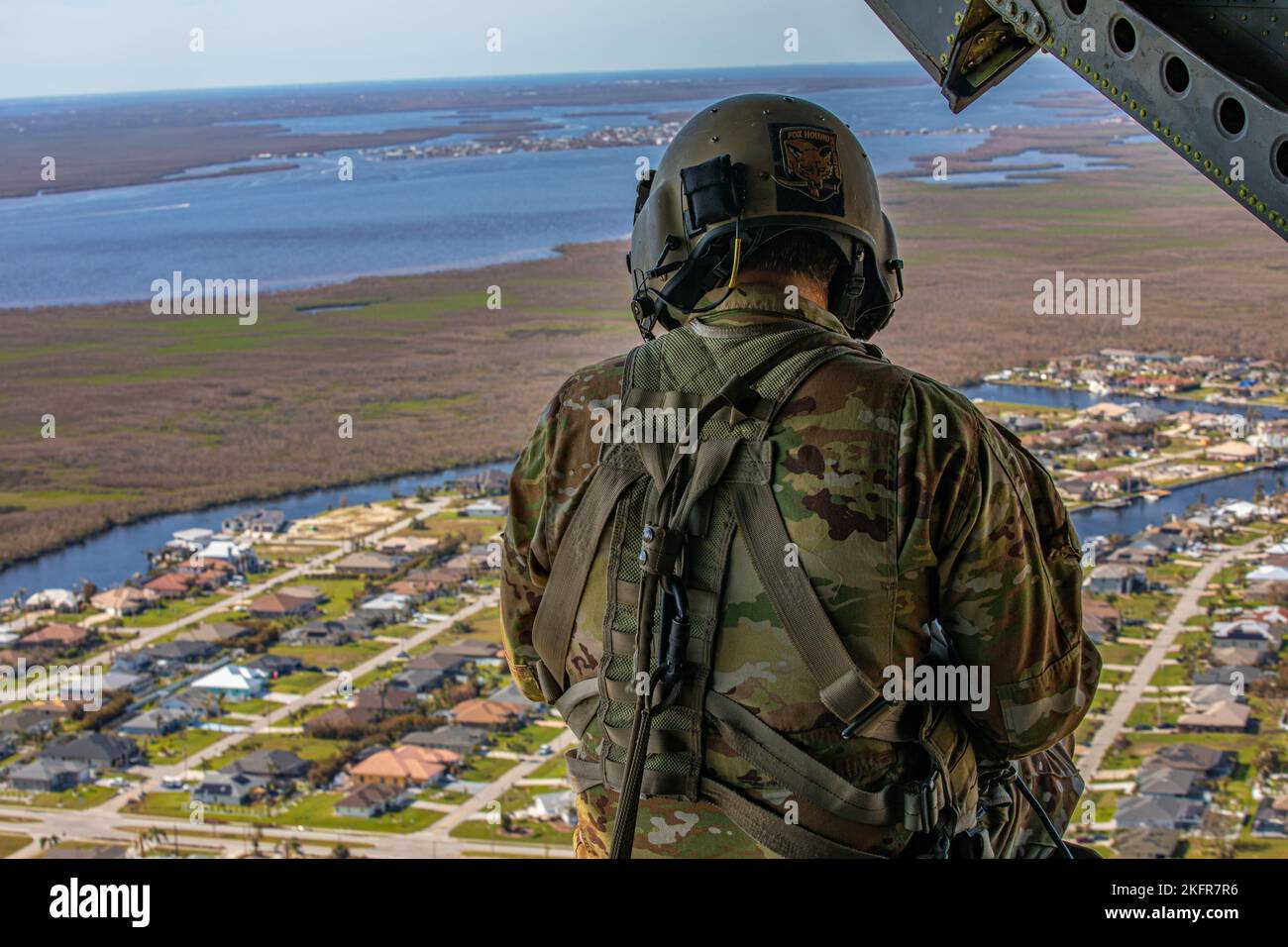 A Florida National Guard (FLNG) crew chief sits upon the ramp of a CH ...