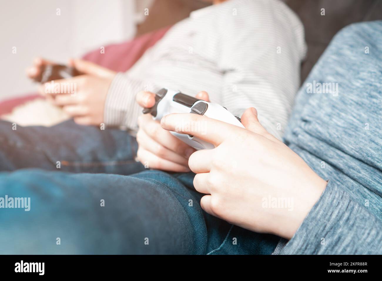 Cropped photo of two teenage boys children sitting on sofa at home ...