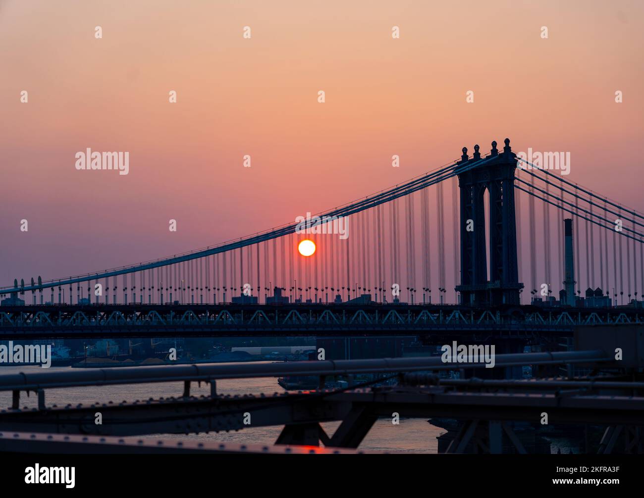 Manhattan bridge at dusk and setting sun disc Stock Photo - Alamy