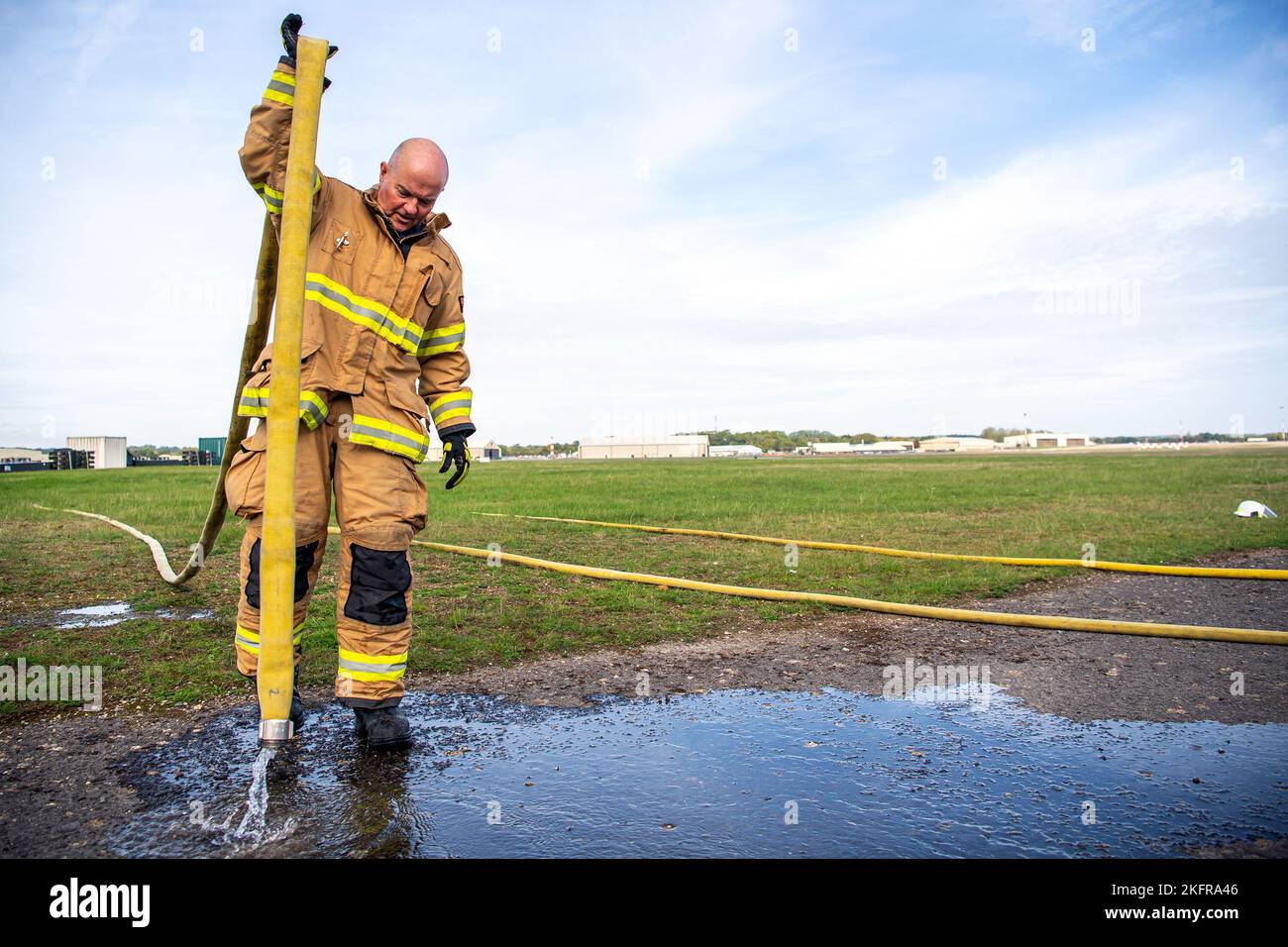 A firefighter from the 422d Fire Emergency Services empties a fire hose ...