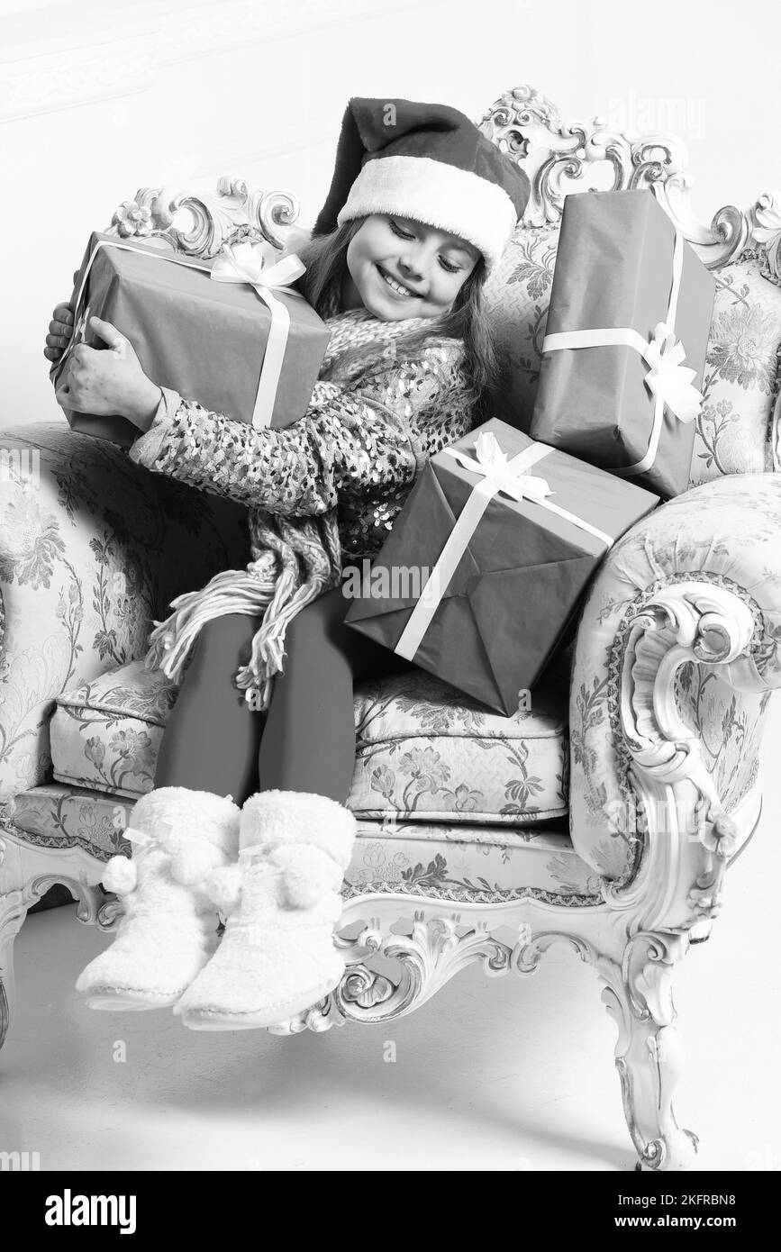 Miss Santa in red hat sits on chic arm chair Stock Photo - Alamy