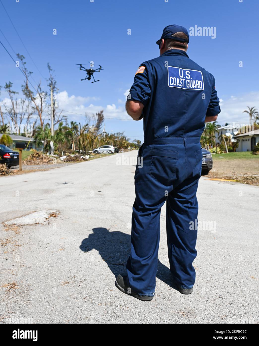 U.S. Coast Guard Petty Officer 1st Class Dylan Zechman flies a drown on ...