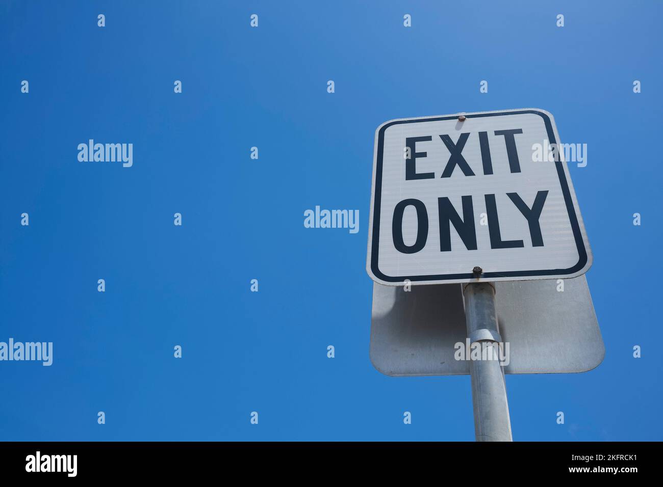 Exit Only road sign against clear blue sky Stock Photo - Alamy