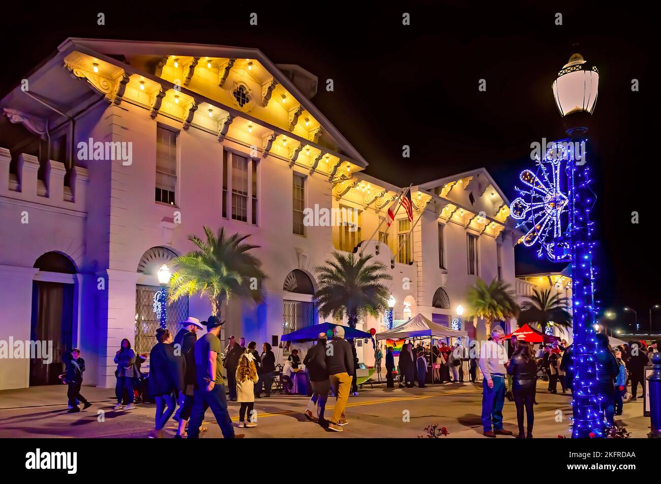 People walk past the History Museum of Mobile during the lighting of ...