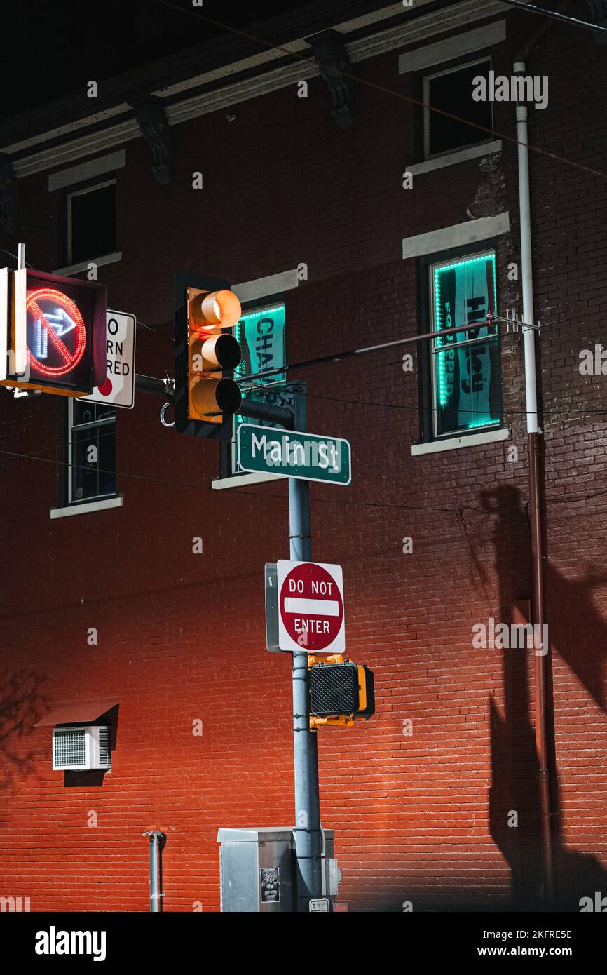 A vertical shot of a traffic light with different sign boards with a ...