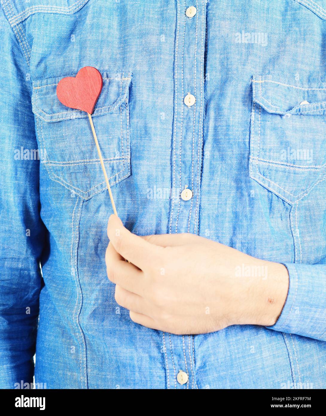 Real love concept. Man holds little red heart and shows his genuinely ...
