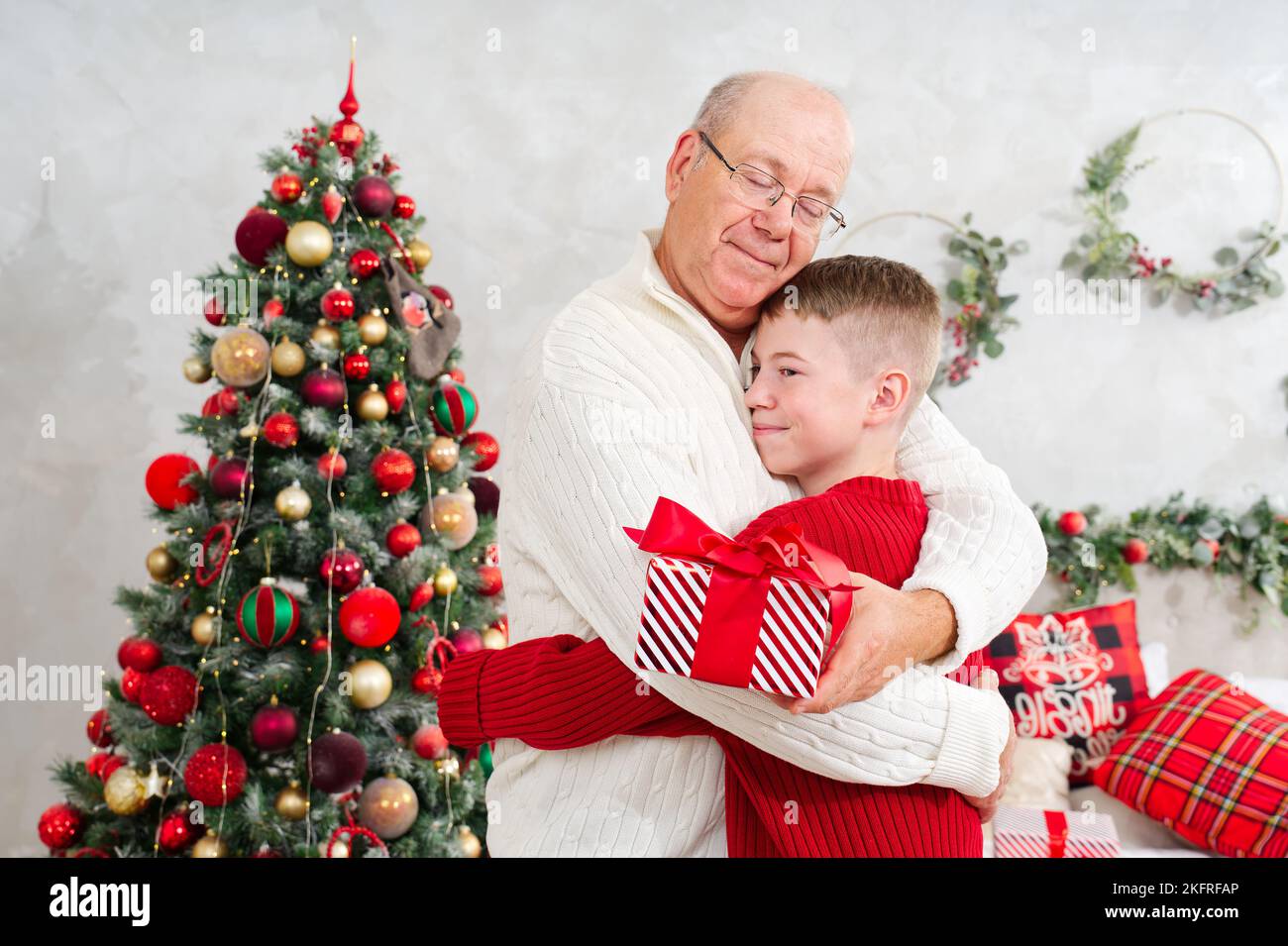 Grandson giving grandpa a Christmas present. Cute little boy is giving ...
