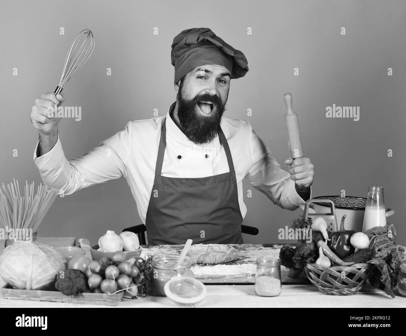 Chef cook in commercial kitchen. Professional chef holds rolling pin ...