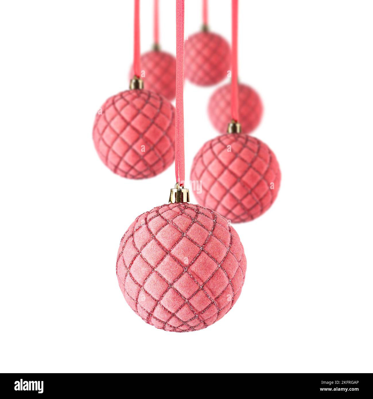 Set of pink Christmas ornaments hanging over white background ...