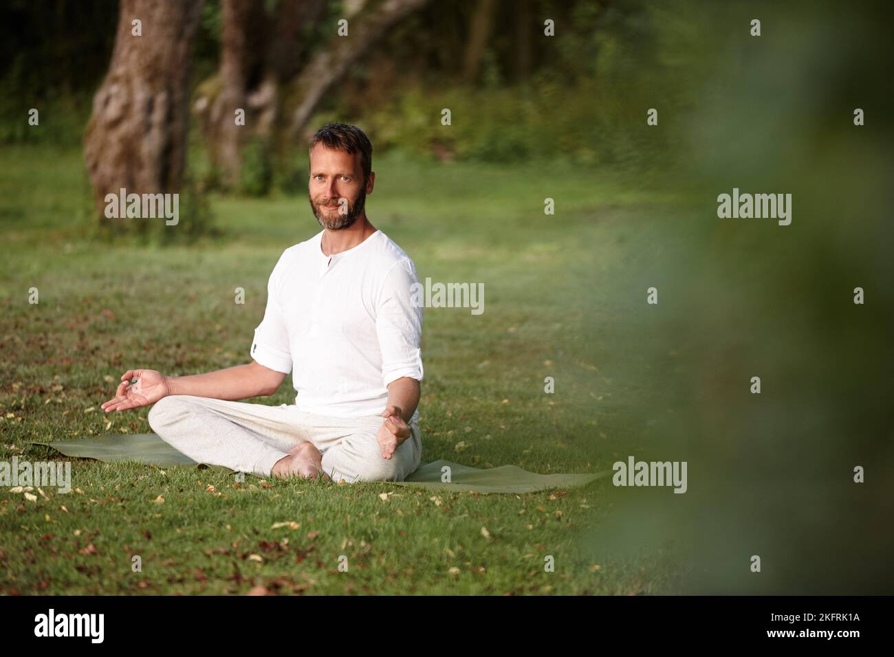 Reflecting in nature. Portrait of a handsome mature man sitting in the ...