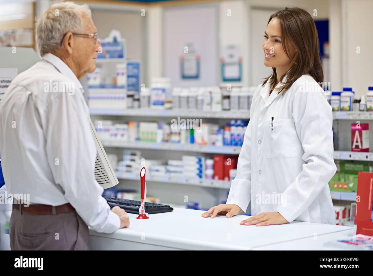 Every customer is important to her. a young pharmacist helping an ...