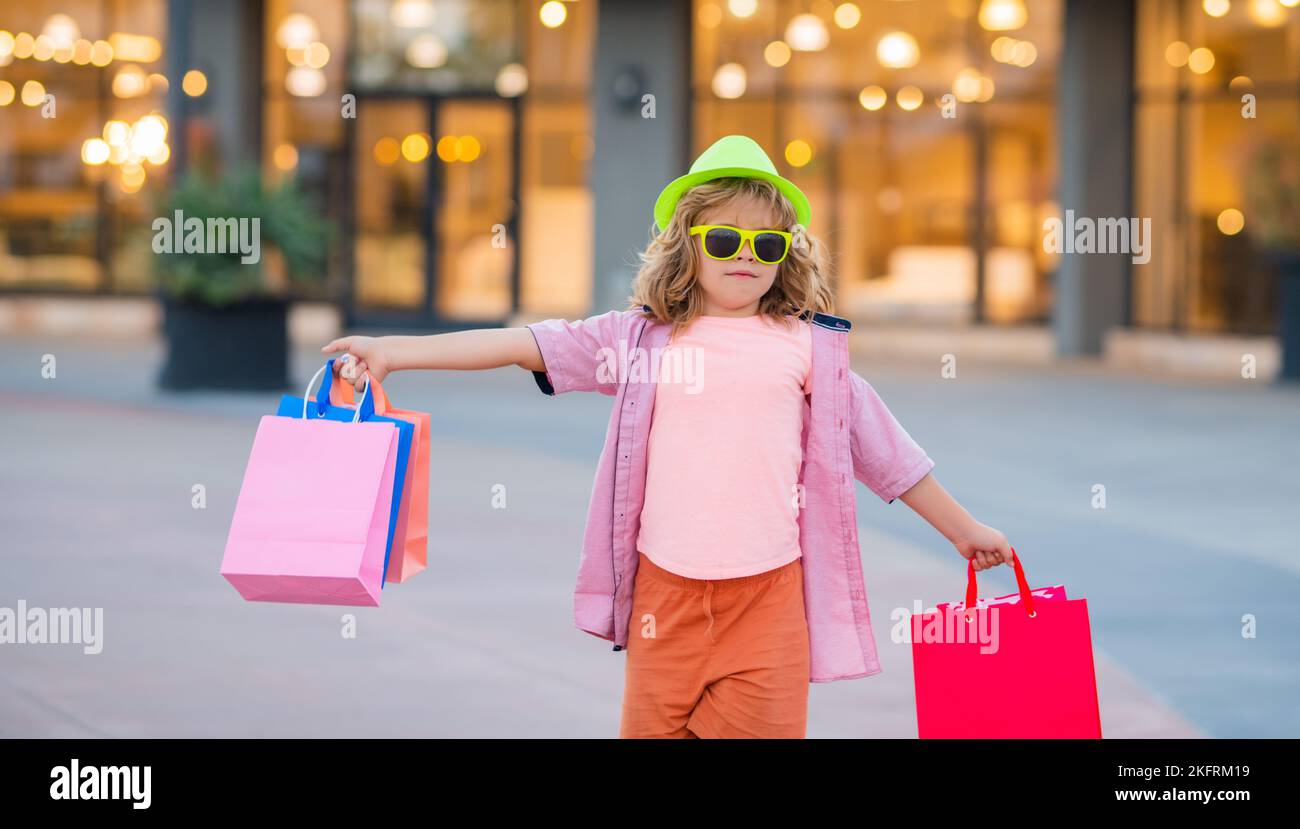 Cute little boy in summer fashion clothes goes shopping. Happy child ...