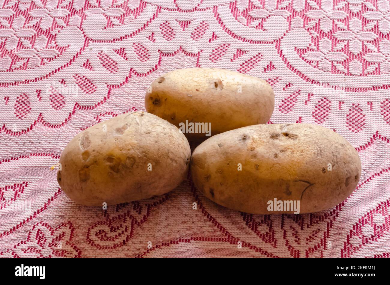 Three Irish potatoes are on a red and white lace tablecloth Stock Photo ...