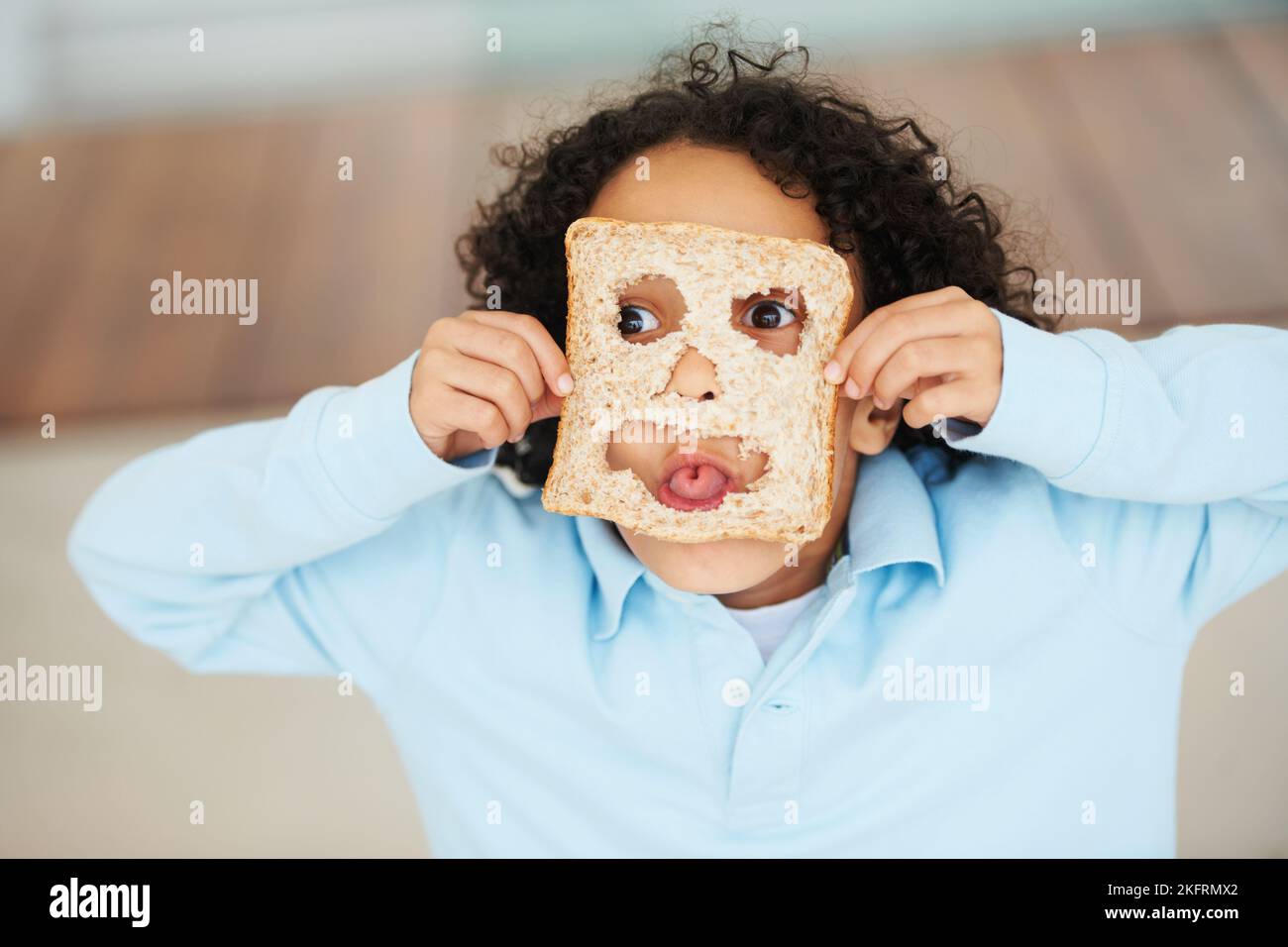 Food makes me happy. a little boy holding up a slice of bread with a ...