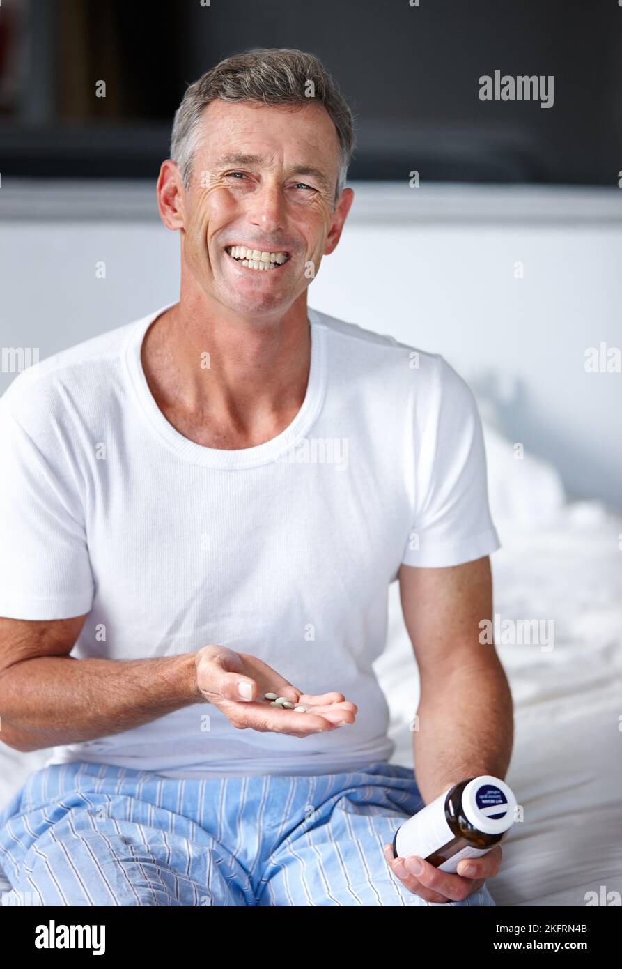 It gives me a daily boost. a mature man sitting on a bed with his ...